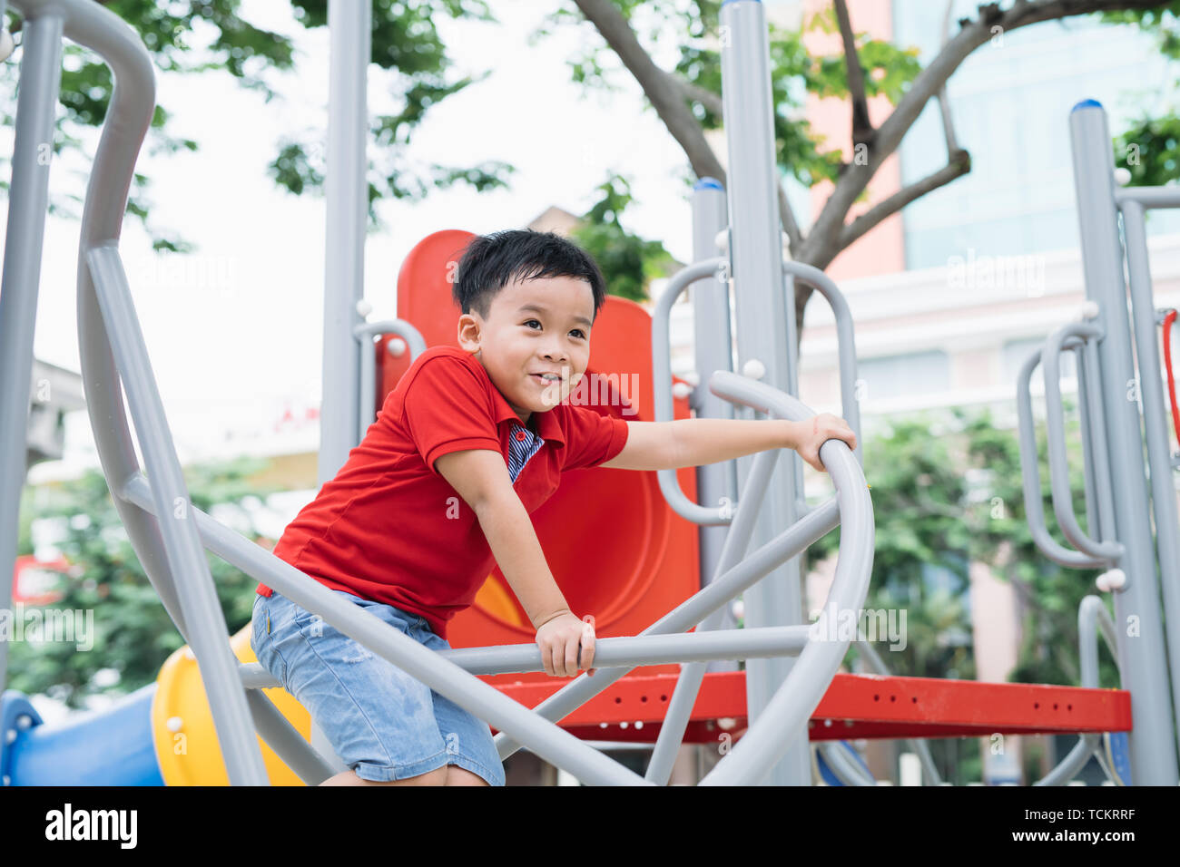 happy little boy climbing on children playground Stock Photo - Alamy
