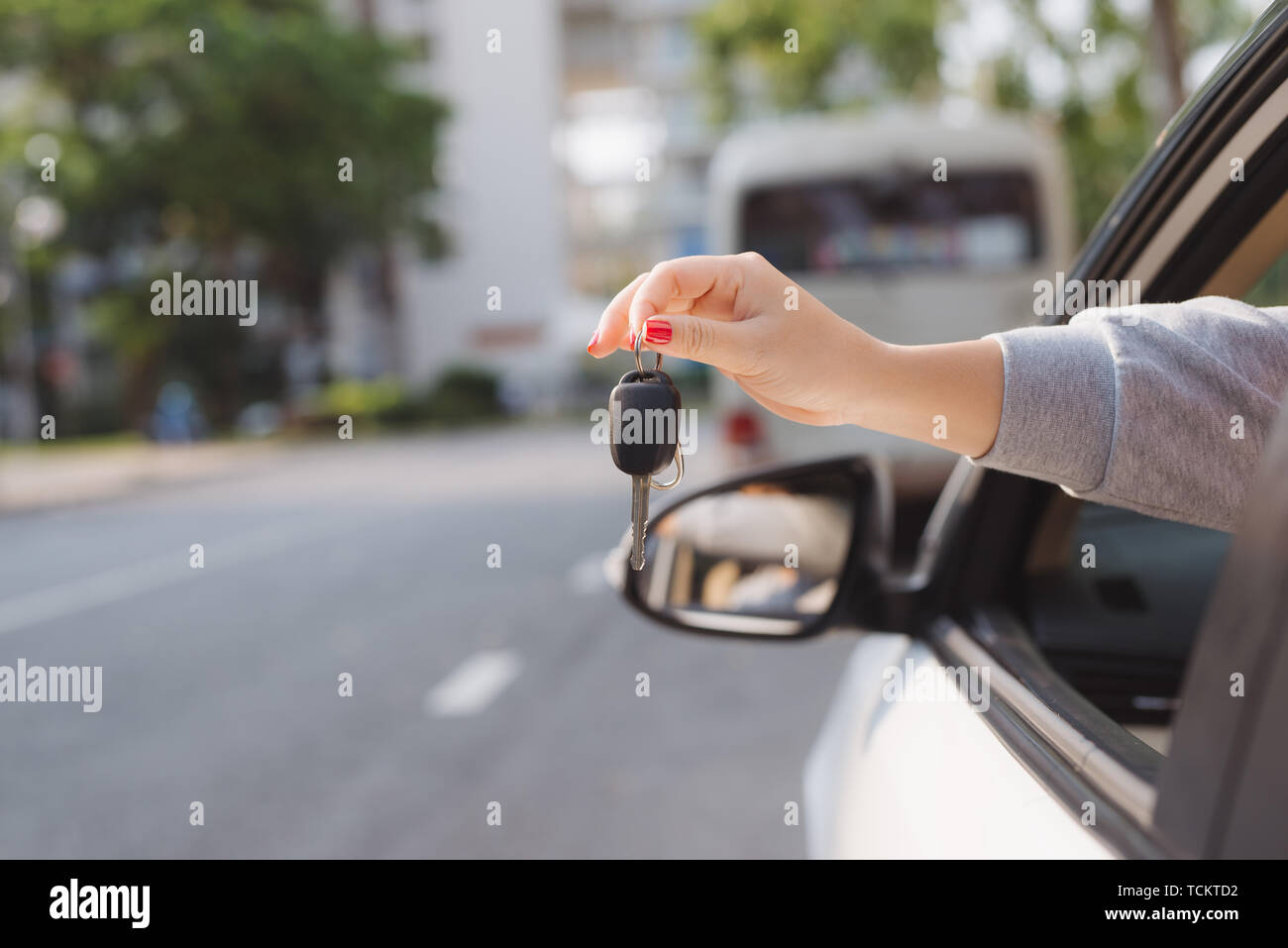Woman holding the ignition keys of a car in her hand dangling them ...
