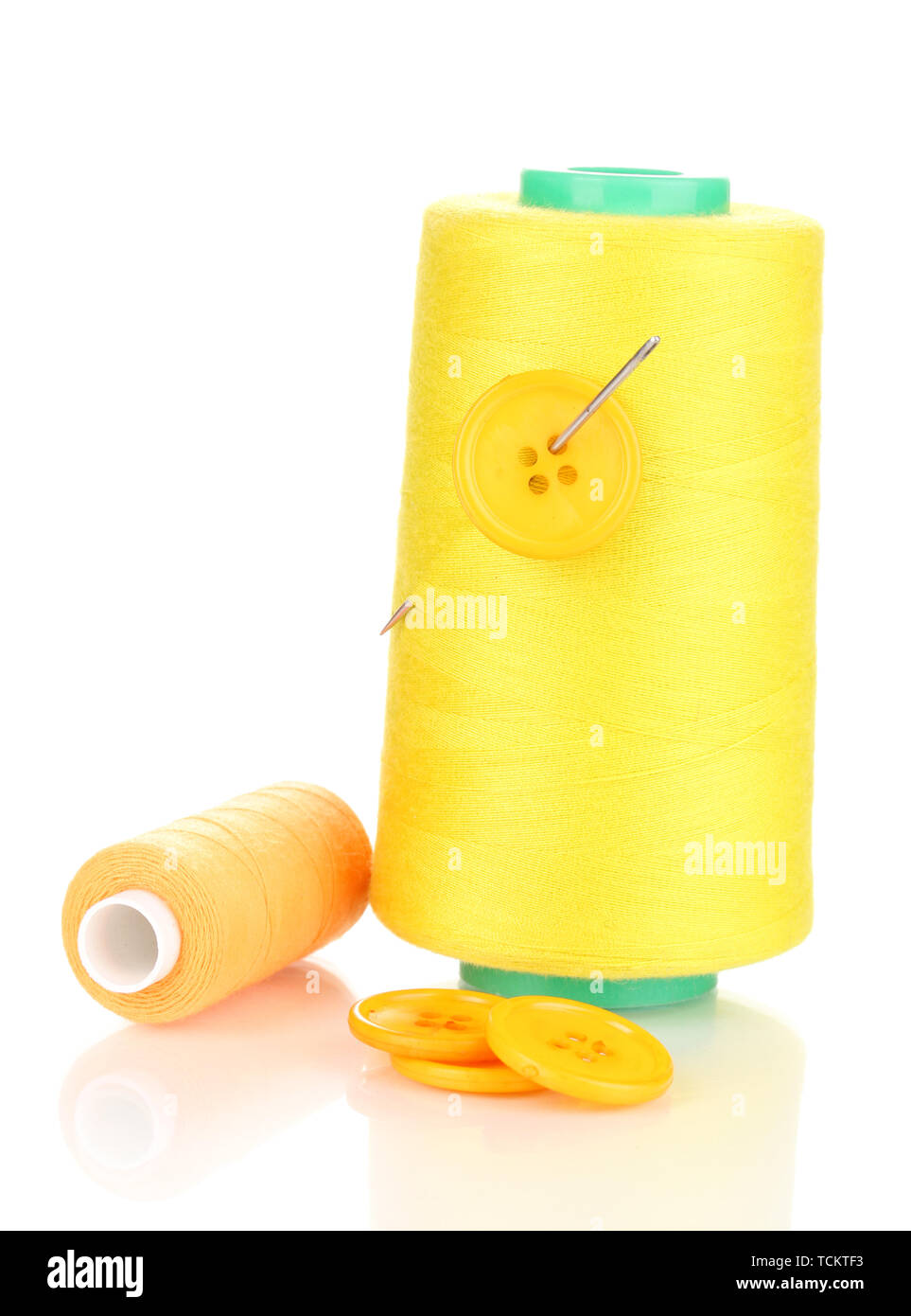Yellow bobbin with needle and buttons isolated on white Stock Photo - Alamy