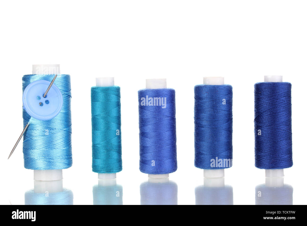 Many blue bobbin with needle and buttons isolated on white Stock Photo ...