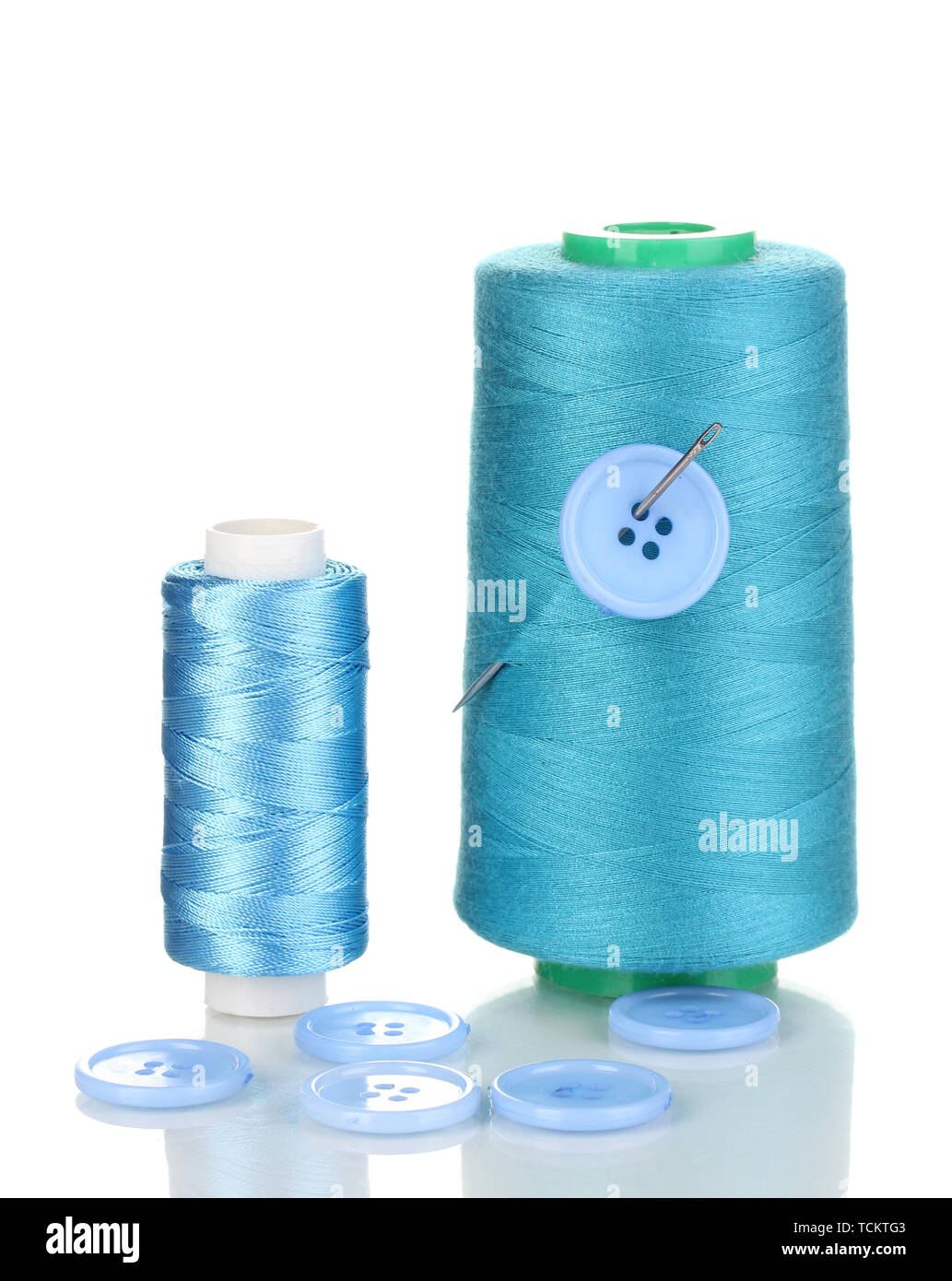 Blue bobbin with needle and buttons isolated on white Stock Photo - Alamy