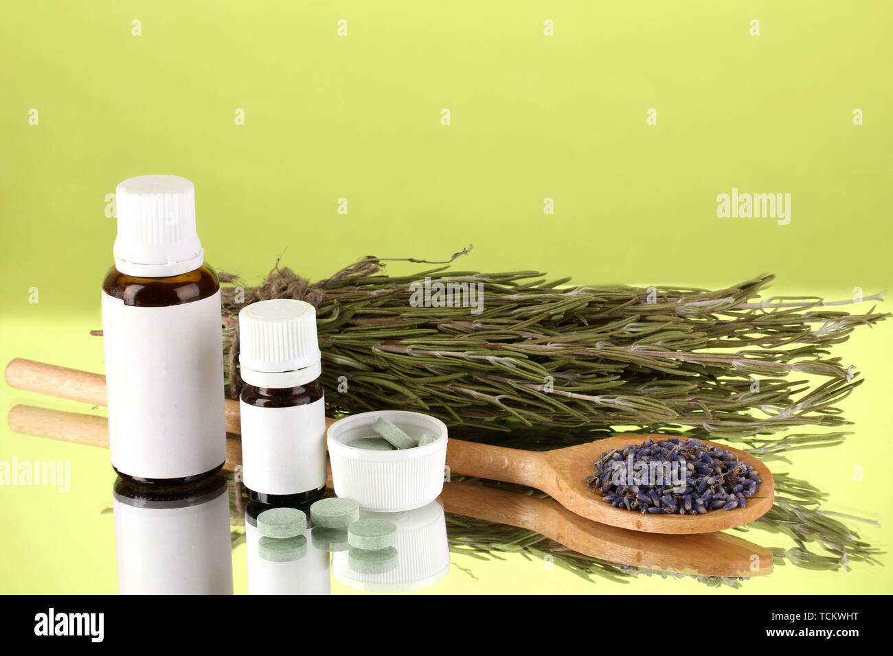 bottles of medicines and herbs on green background. concept of ...