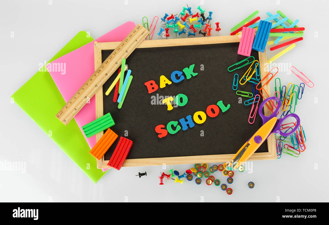 Small chalkboard with school supplies on white background. Back to ...
