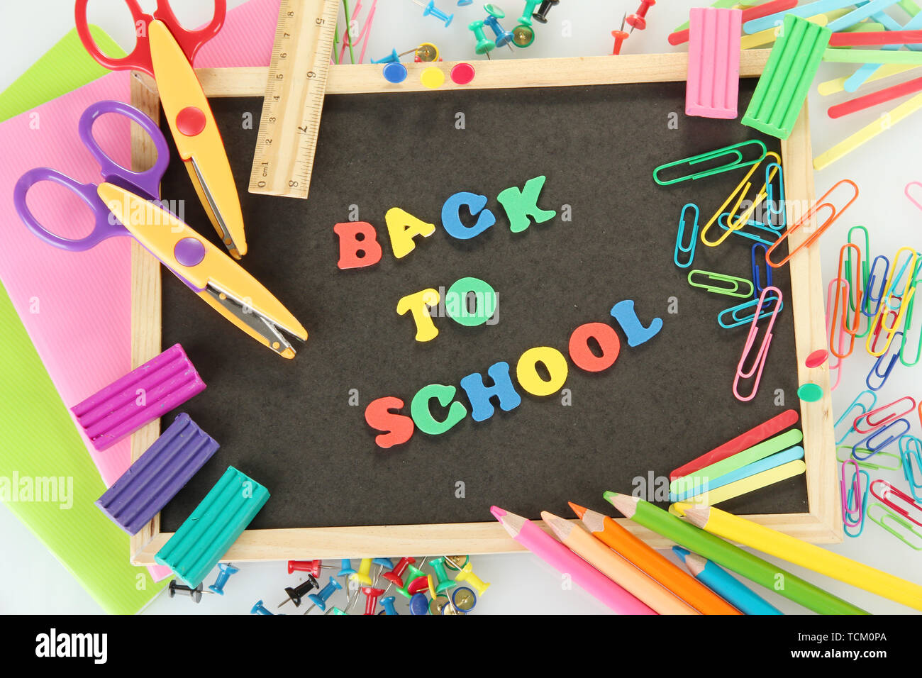 Small chalkboard with school supplies on white background. Back to ...