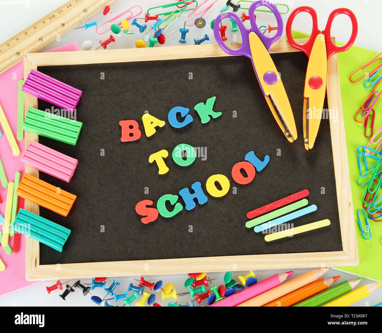 Small chalkboard with school supplies on white background. Back to ...