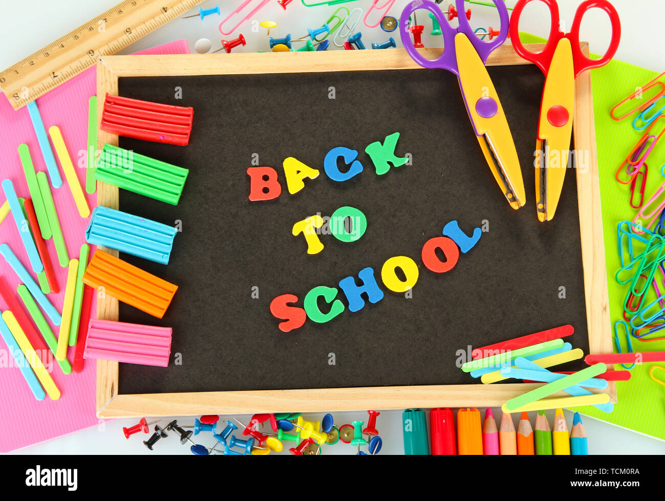 Small chalkboard with school supplies on white background. Back to ...