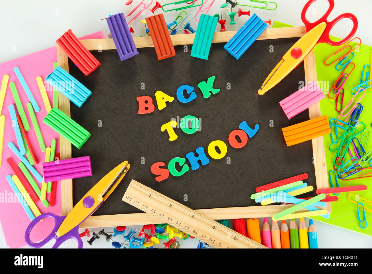Small chalkboard with school supplies on white background. Back to ...