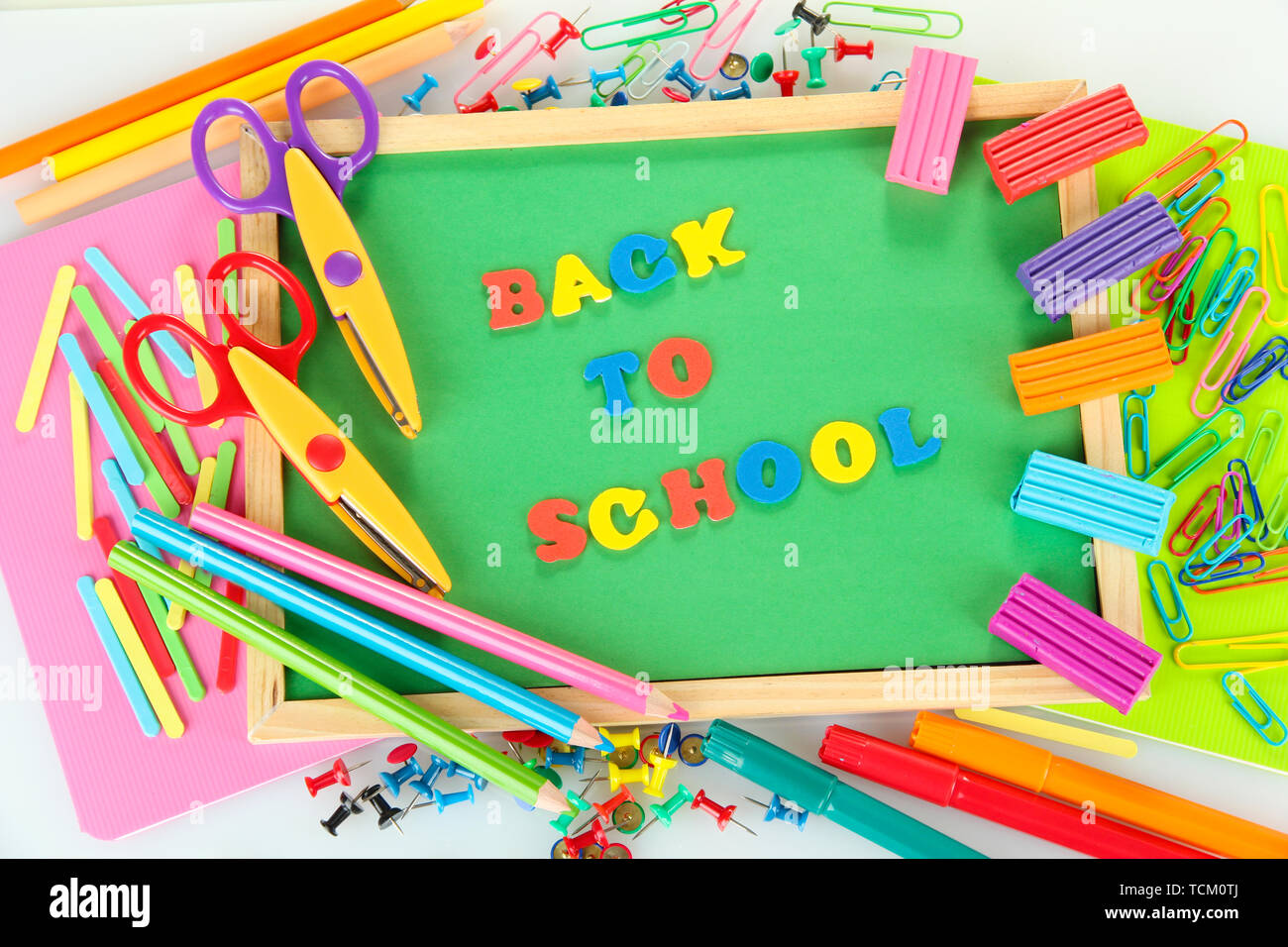 Small chalkboard with school supplies on white background. Back to ...