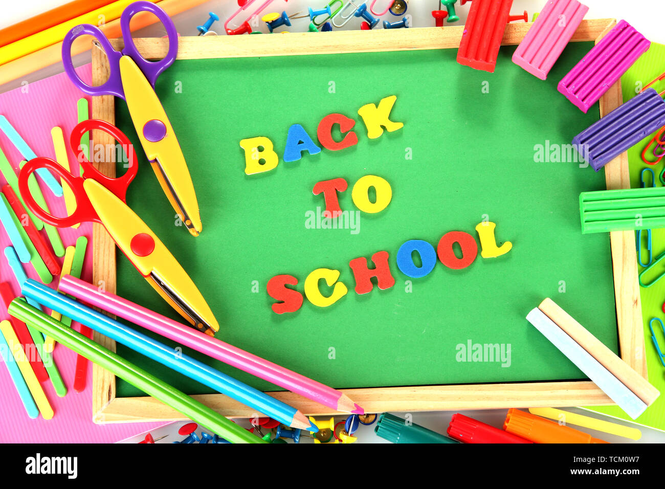 Small chalkboard with school supplies on white background. Back to ...