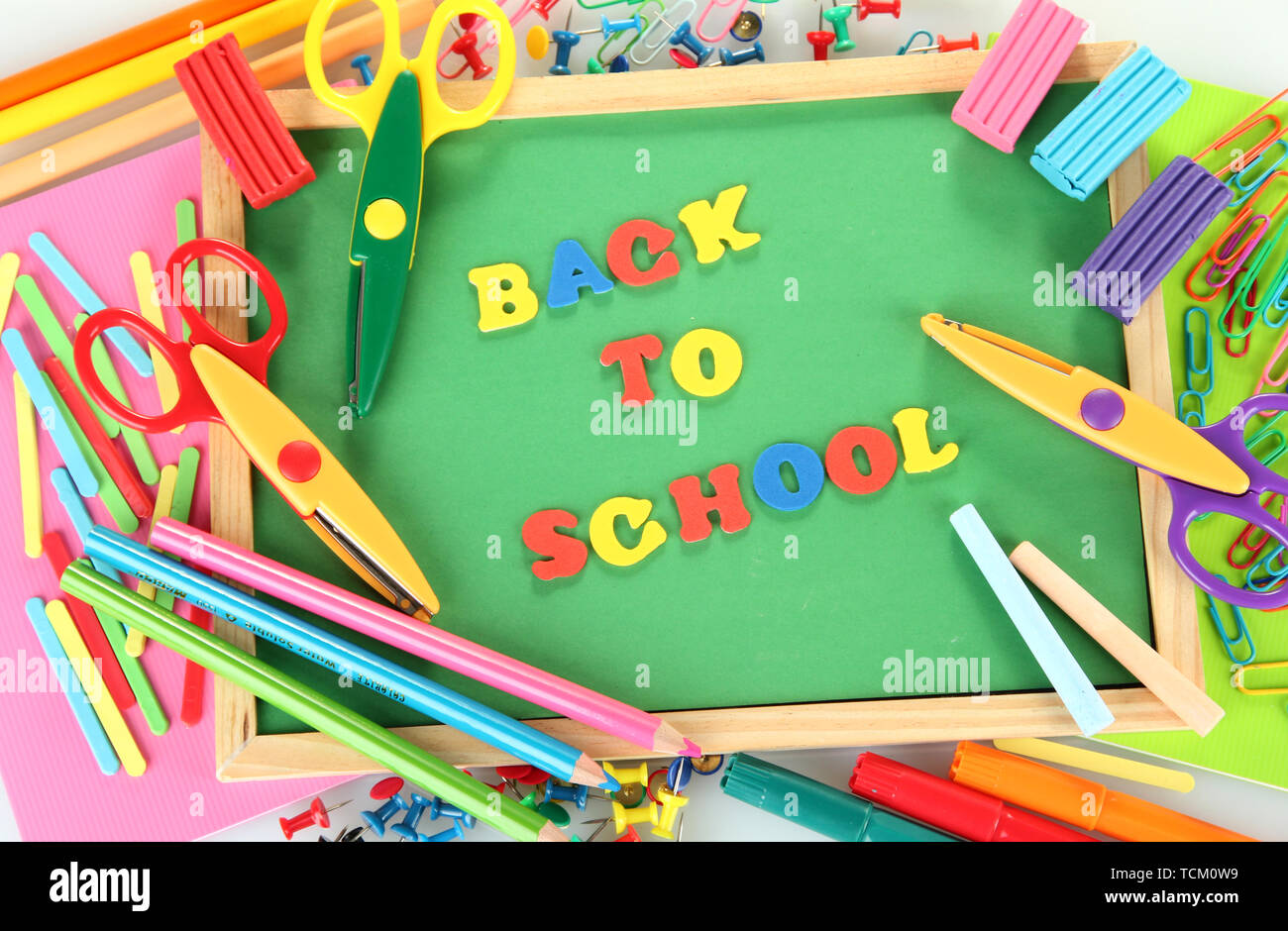 Small chalkboard with school supplies on white background. Back to ...