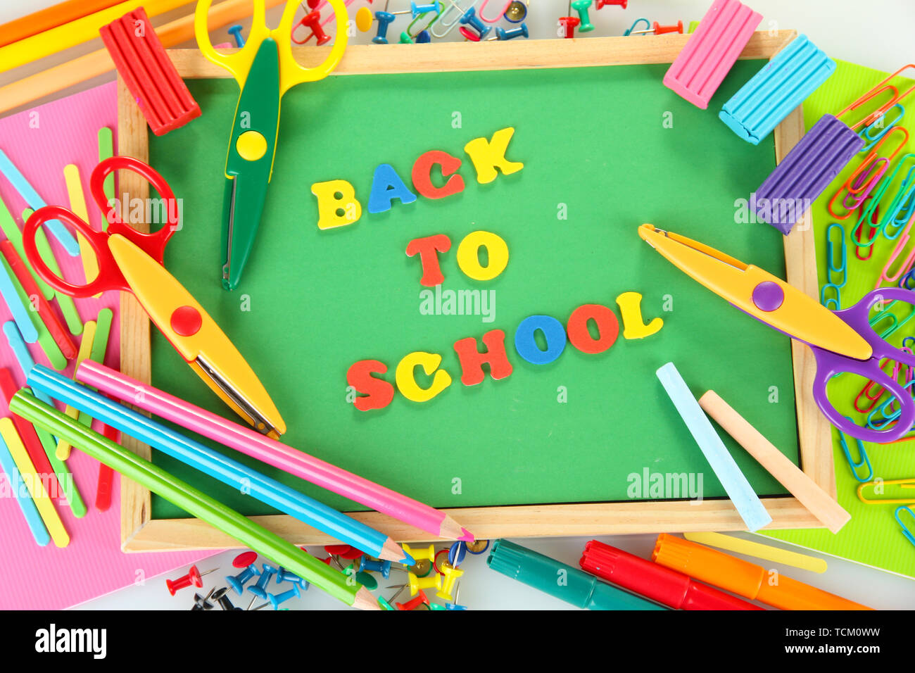 Small chalkboard with school supplies on white background. Back to ...