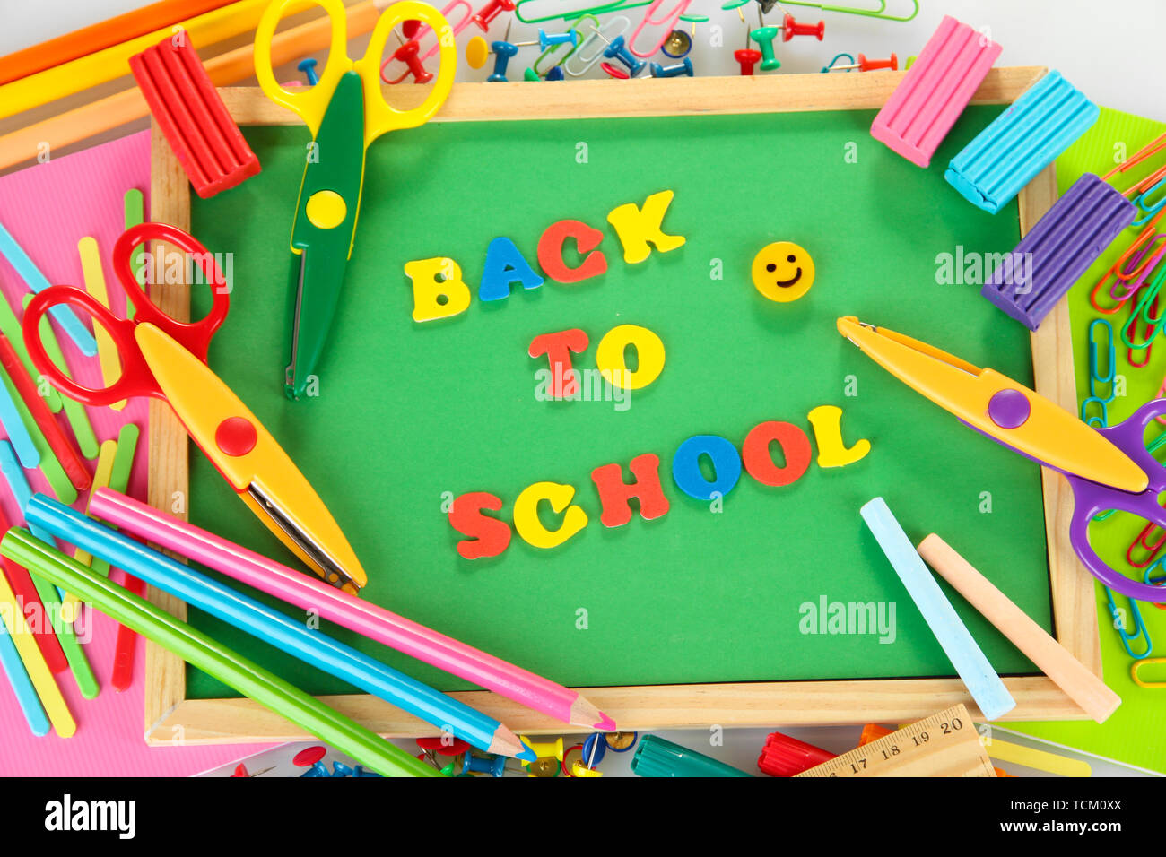 Small chalkboard with school supplies on white background. Back to ...