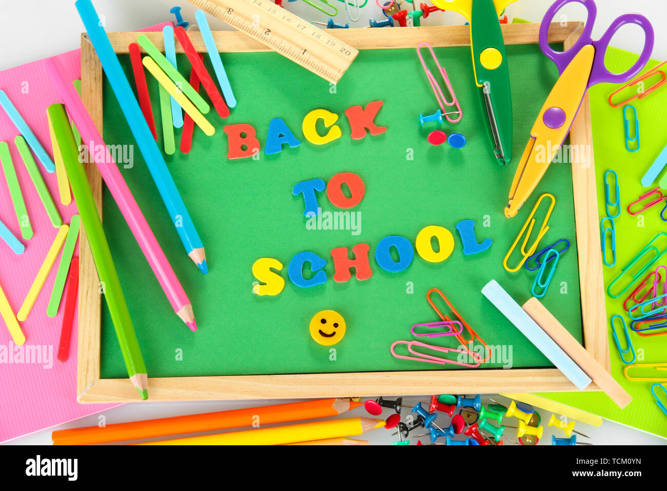 Small chalkboard with school supplies on white background. Back to ...