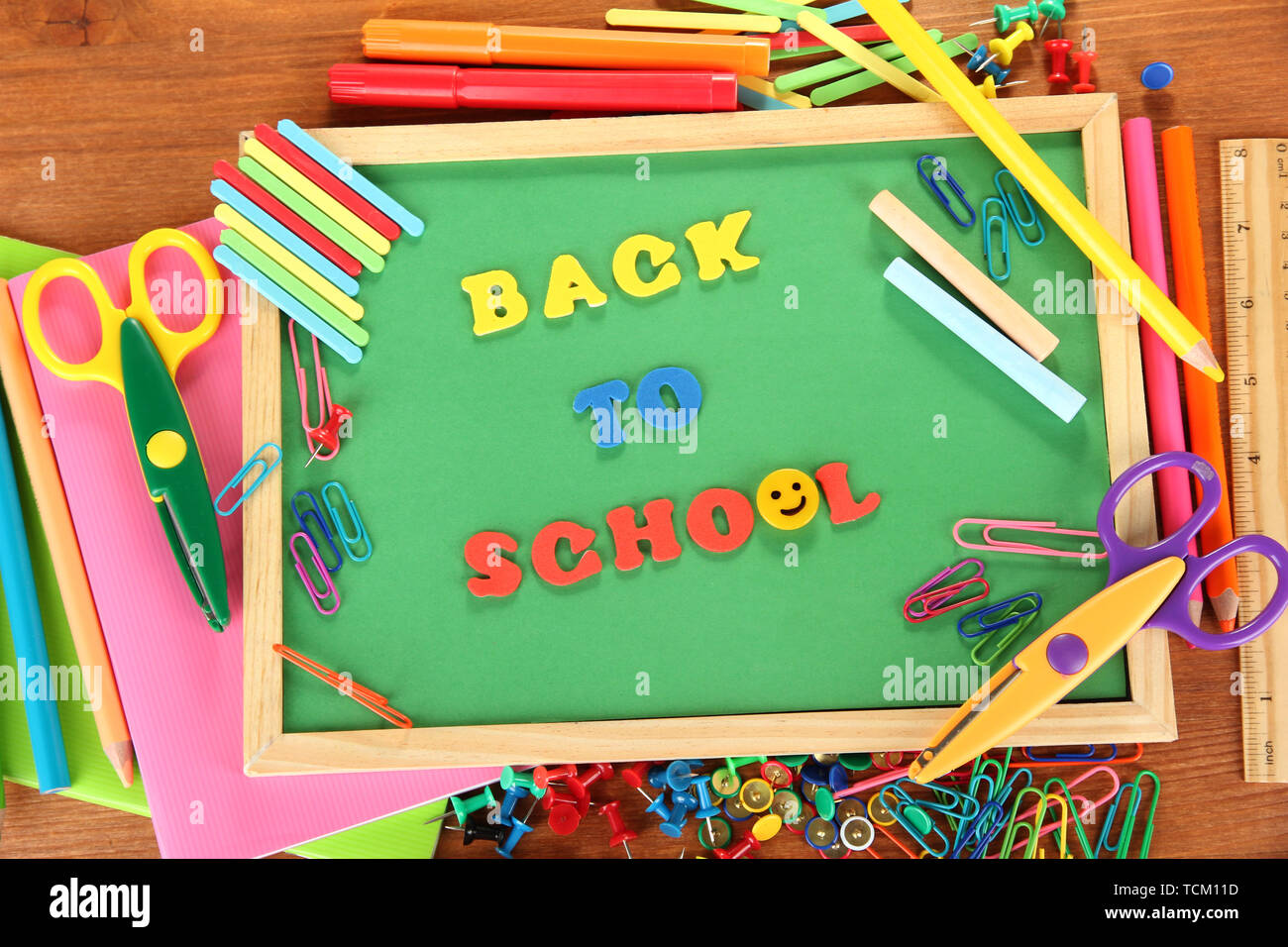 Small chalkboard with school supplies on wooden background. Back to ...