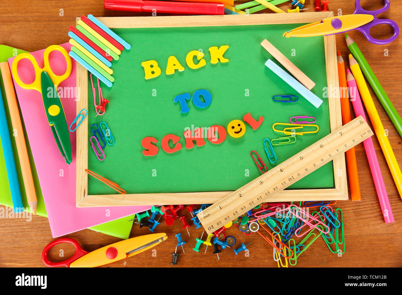 Small chalkboard with school supplies on wooden background. Back to ...