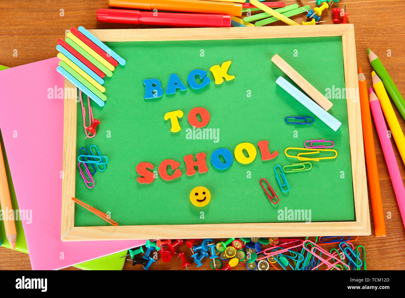 Small chalkboard with school supplies on wooden background. Back to ...