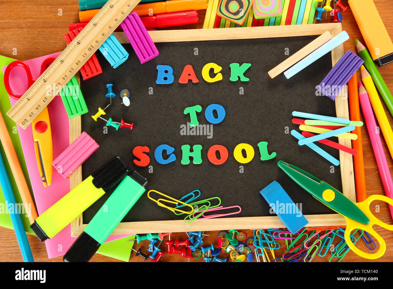 Small chalkboard with school supplies on wooden background. Back to ...