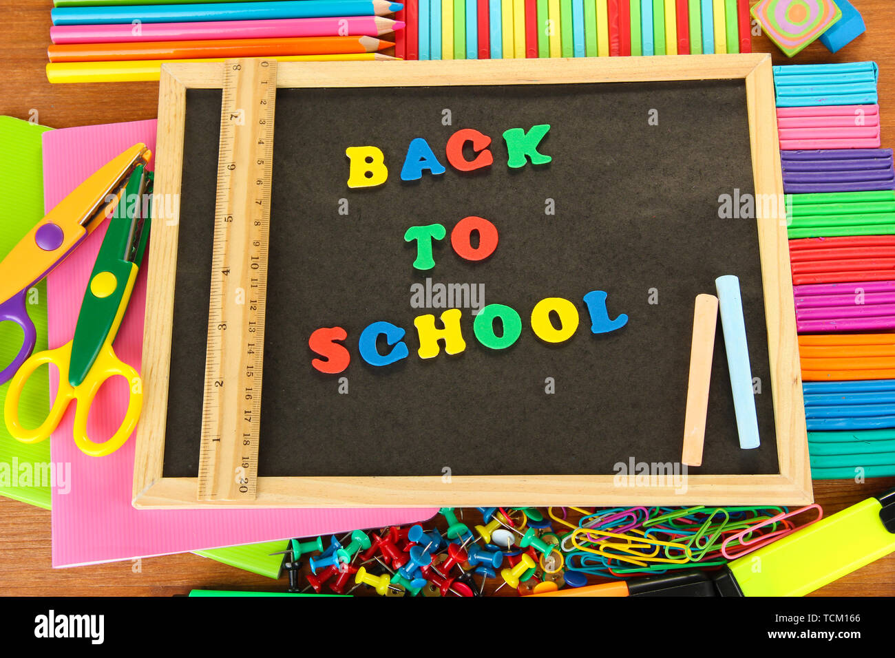 Small chalkboard with school supplies on wooden background. Back to ...
