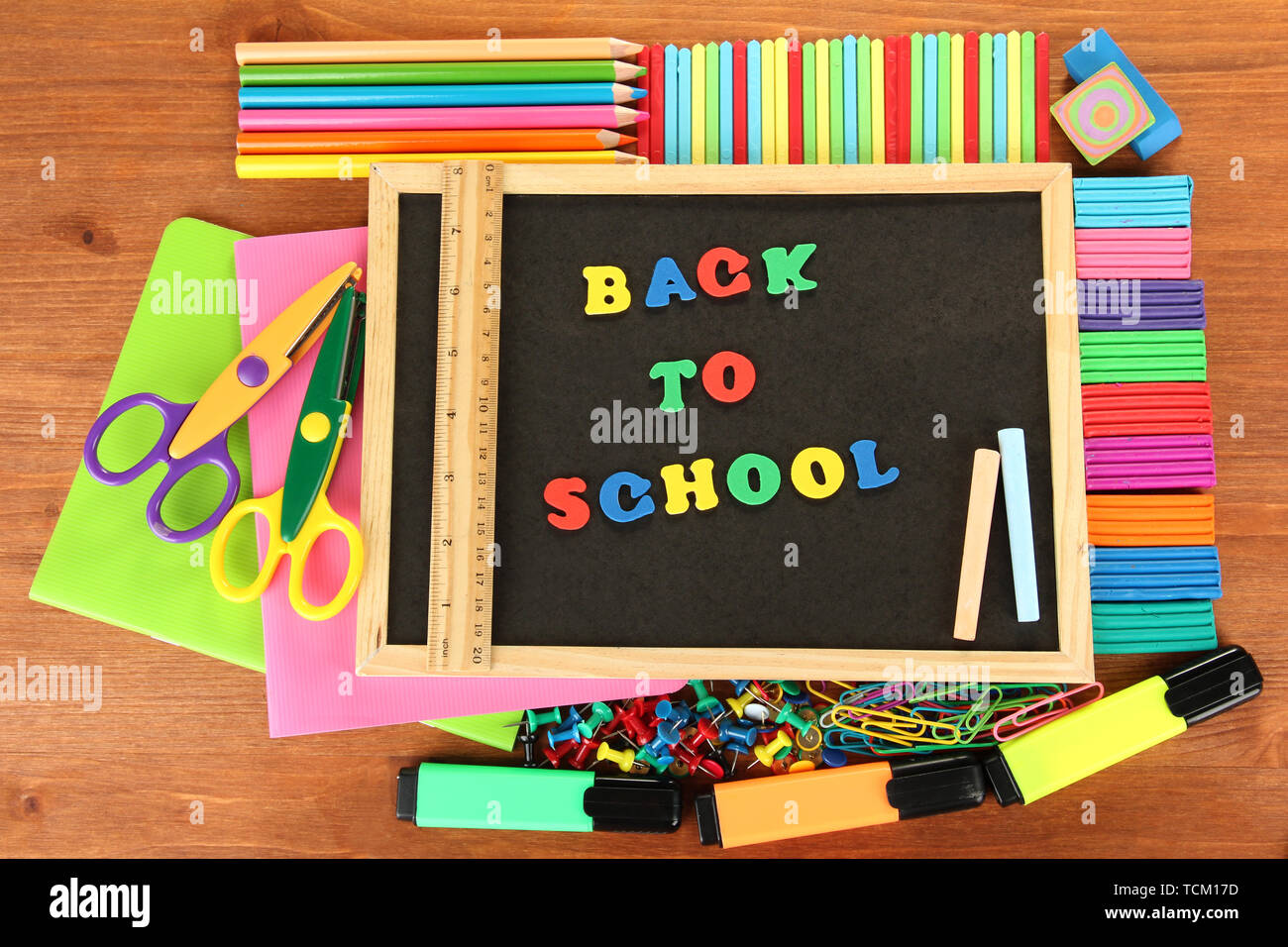 Small chalkboard with school supplies on wooden background. Back to ...