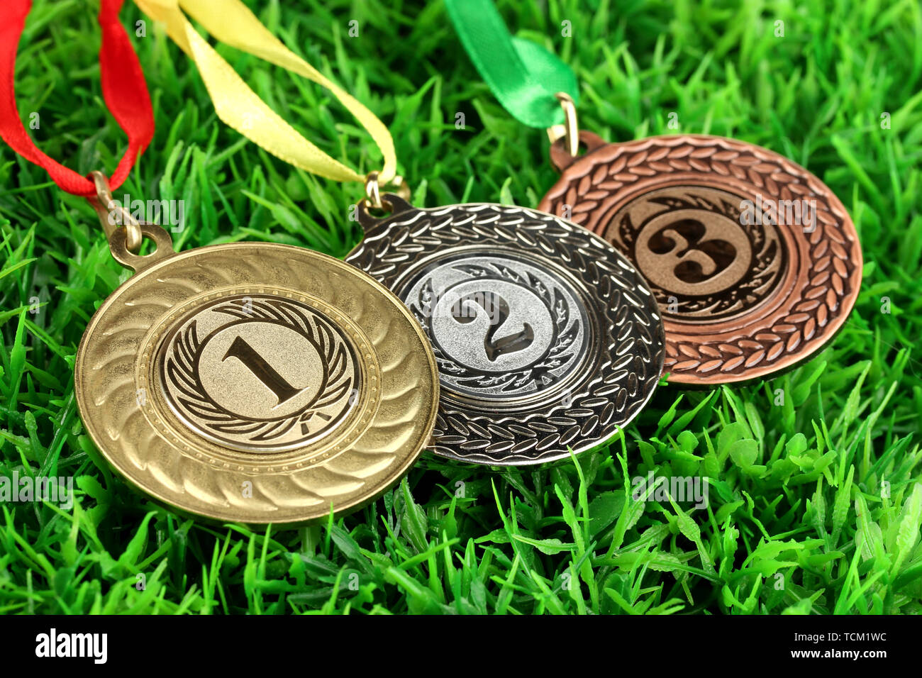 Three medals on grass background Stock Photo - Alamy