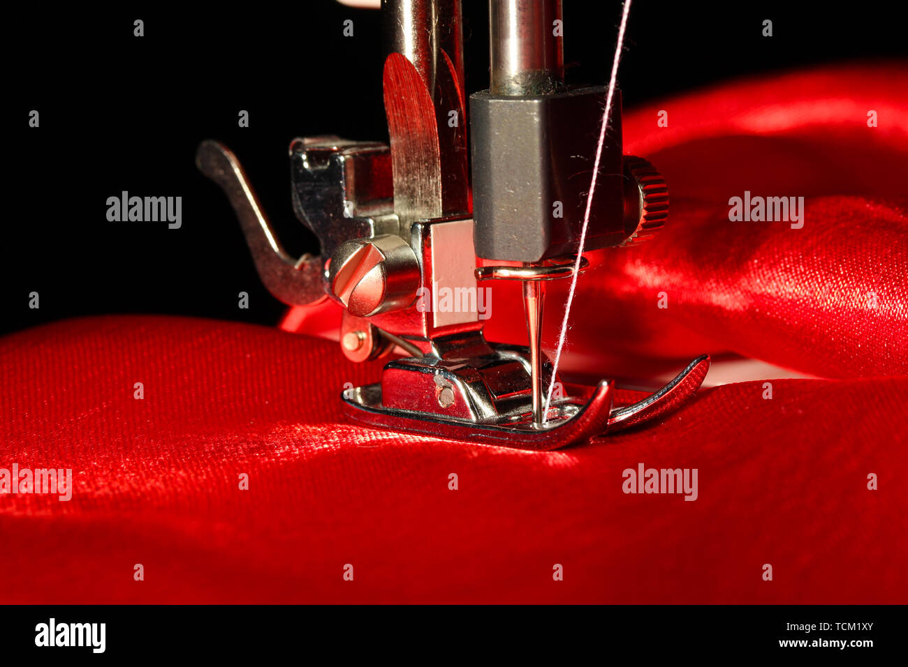 Sewing machine with red cloth closeup Stock Photo - Alamy