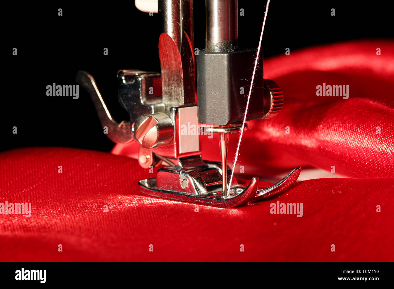 Sewing machine with red cloth closeup Stock Photo - Alamy