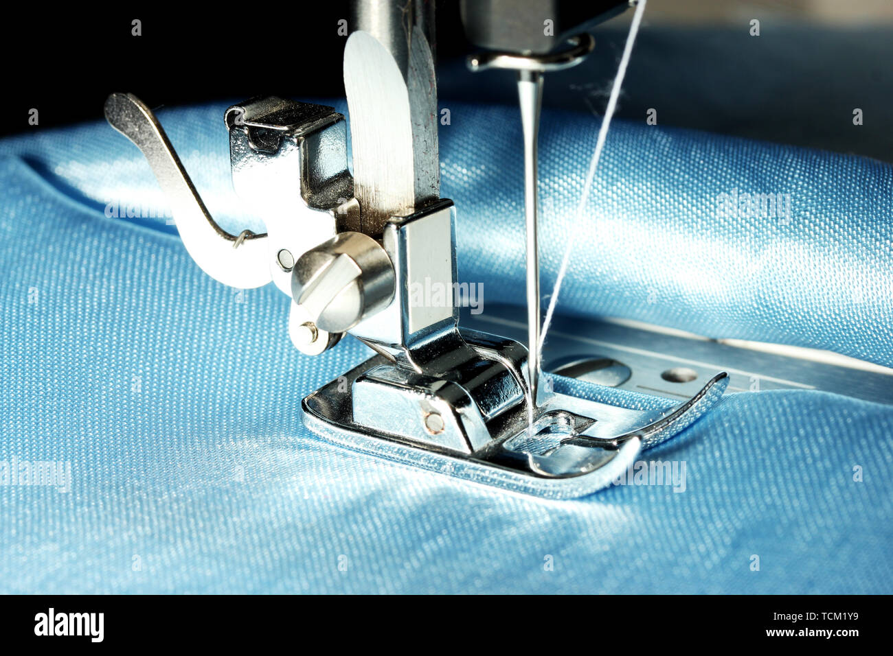 Sewing machine with blue cloth closeup Stock Photo - Alamy