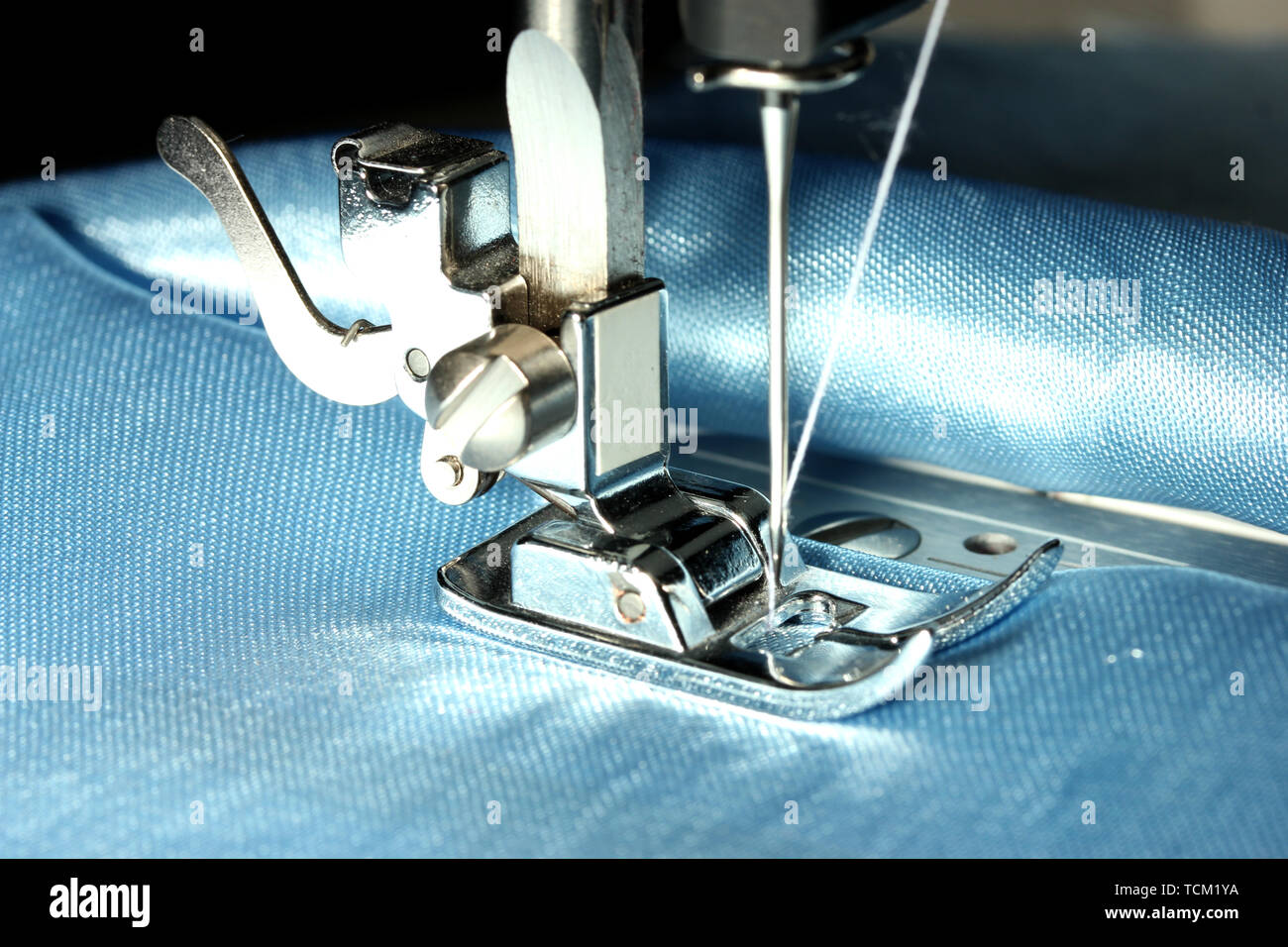 Sewing machine with blue cloth closeup Stock Photo - Alamy