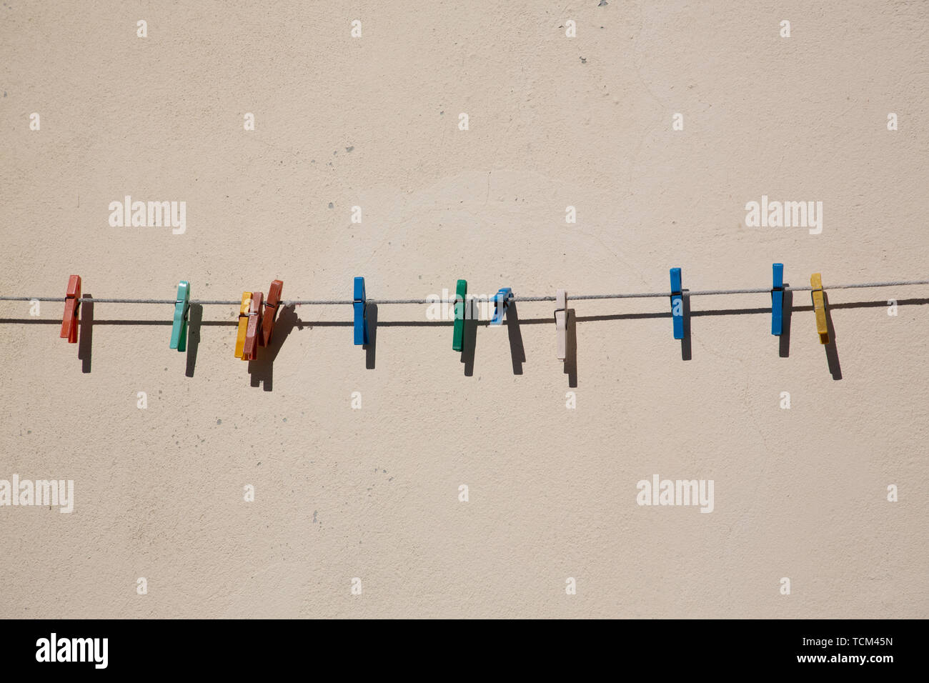 Simple array of colourful clothes pegs or clothes pins on washing line ...