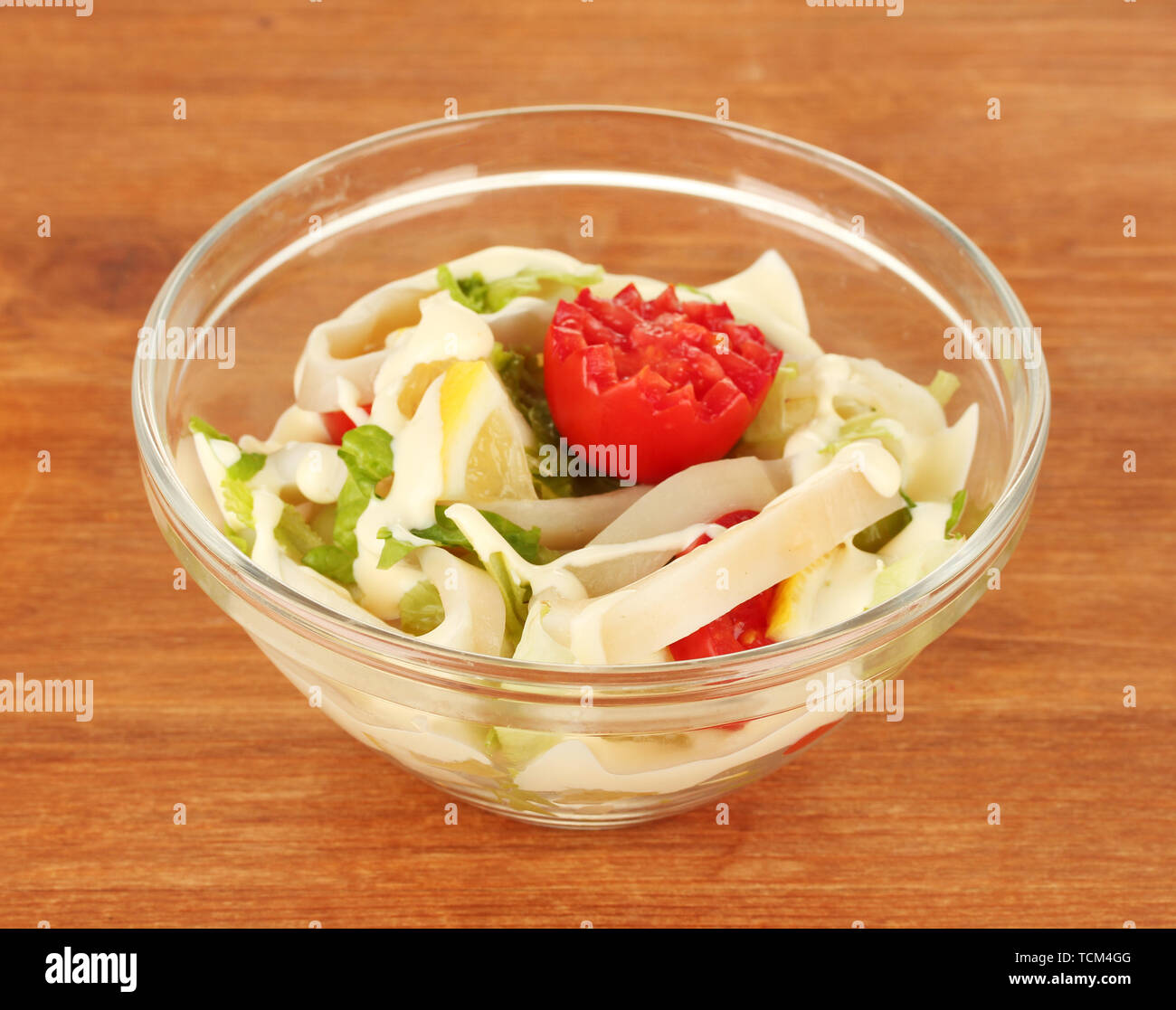 squid salad with vegetables in a glass bowl on wooden background close ...