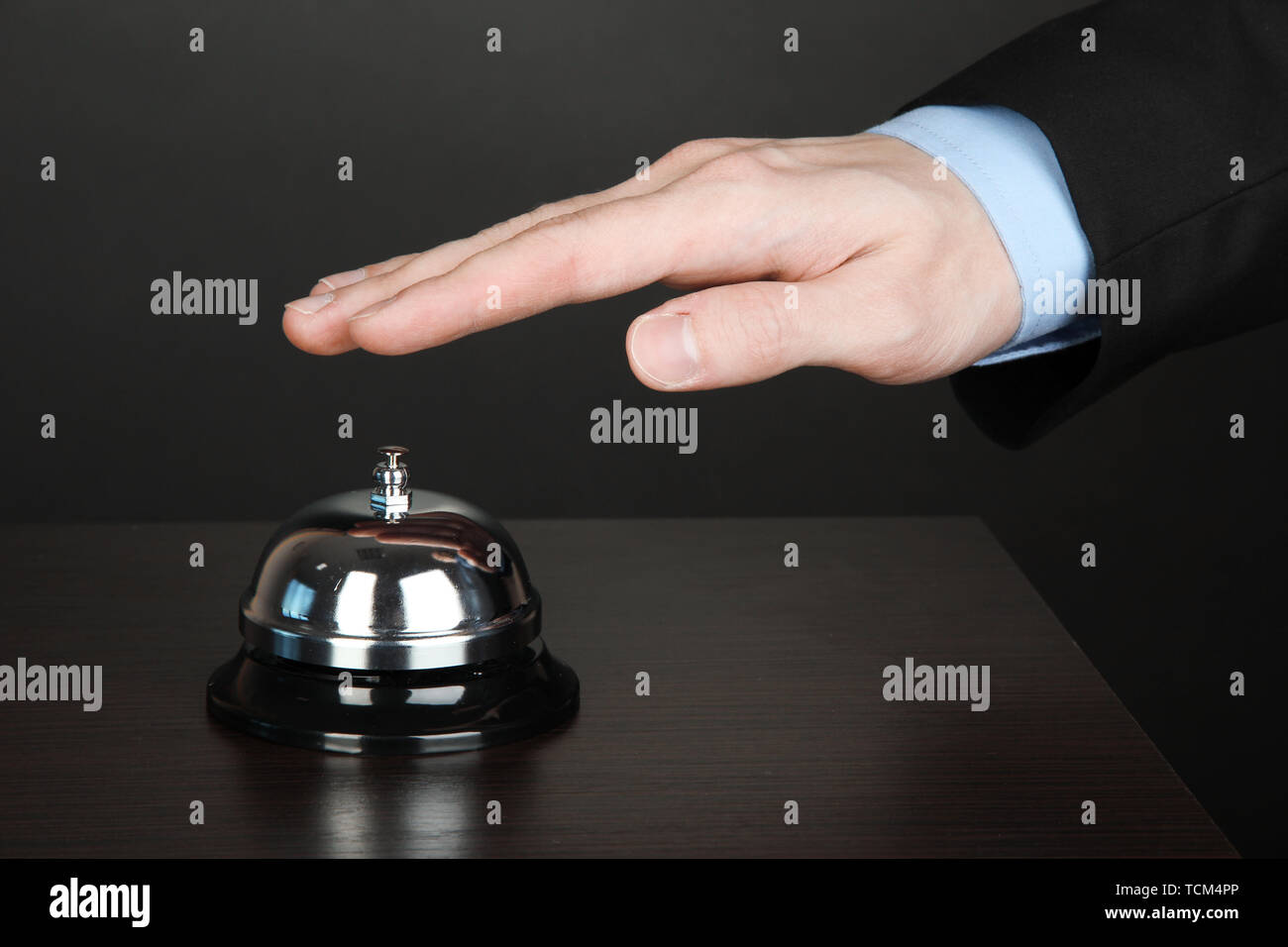 Hand ringing in service bell on wooden table on black background Stock ...