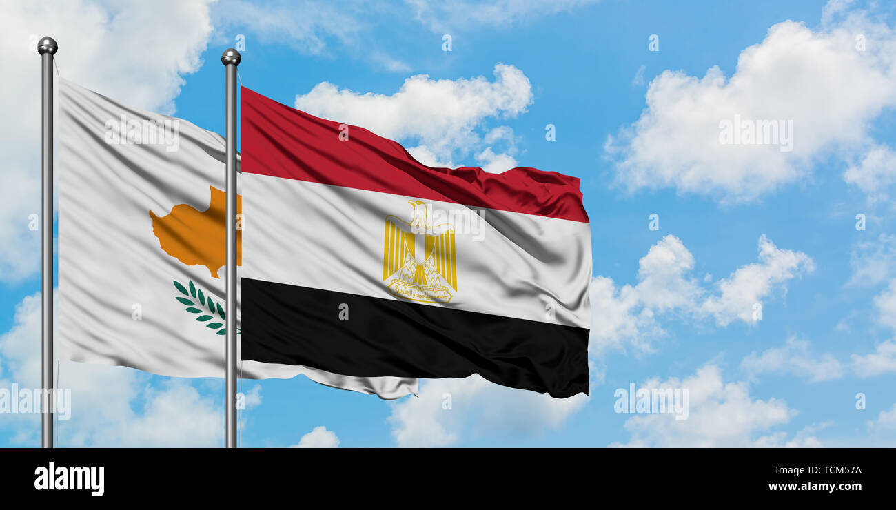 Cyprus and Egypt flag waving in the wind against white cloudy blue sky ...