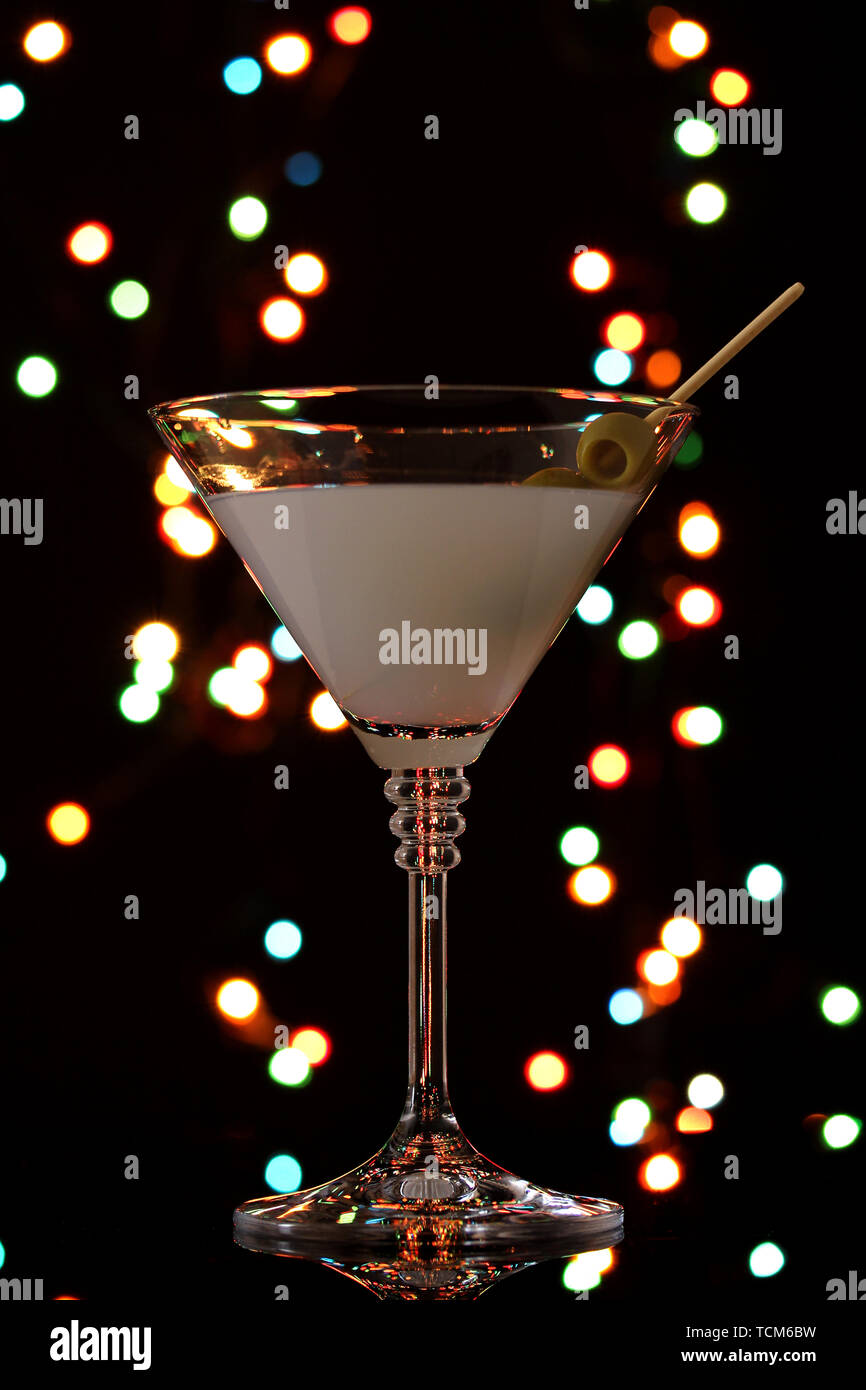 Martini glass and olives on dark bright background Stock Photo - Alamy