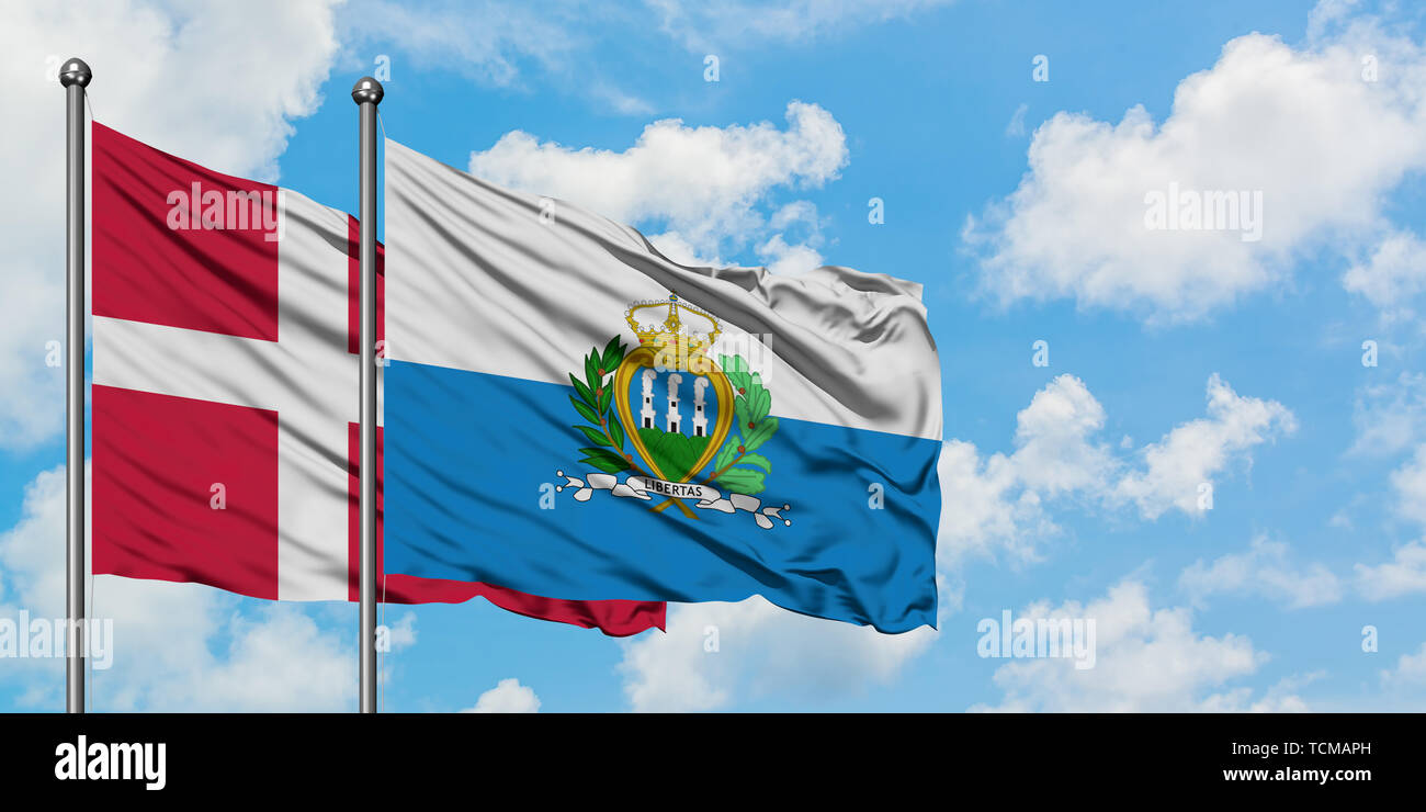 Denmark and San Marino flag waving in the wind against white cloudy ...