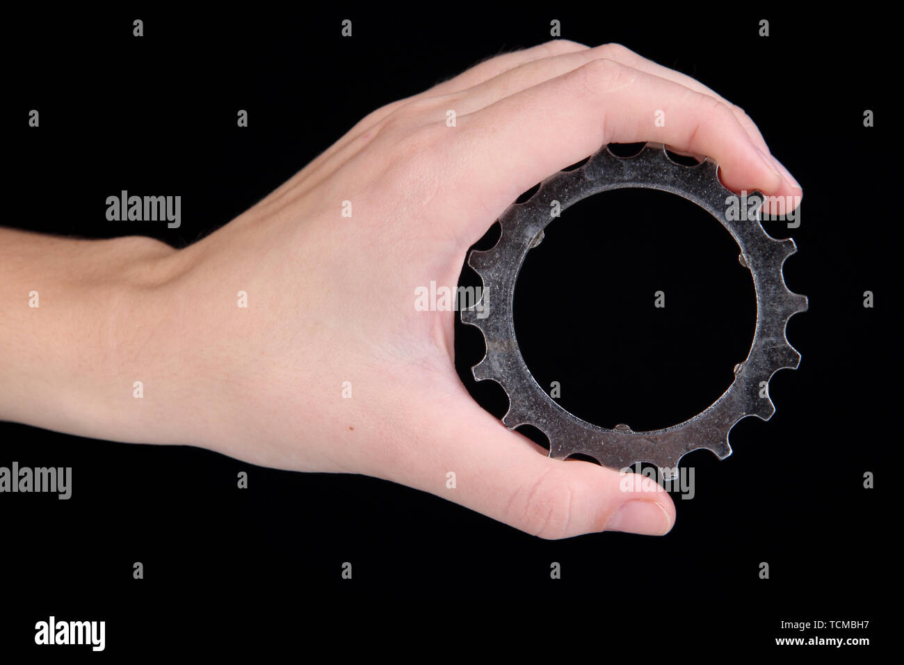 Man holding metallic cogwheel in his hand on black background Stock ...