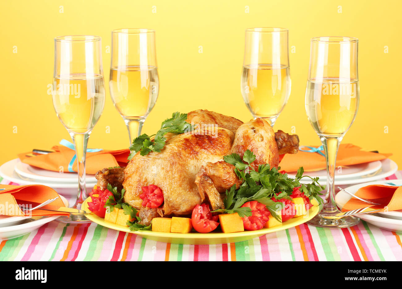 banquet table with roast chicken on orange background close-up ...