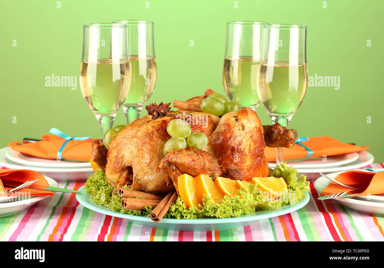banquet table with roast chicken on green background close-up ...