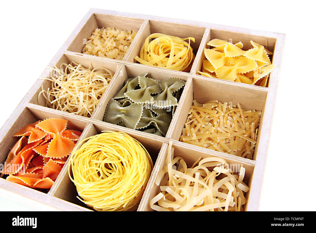 Nine types of pasta in wooden box sections close-up isolated on white ...