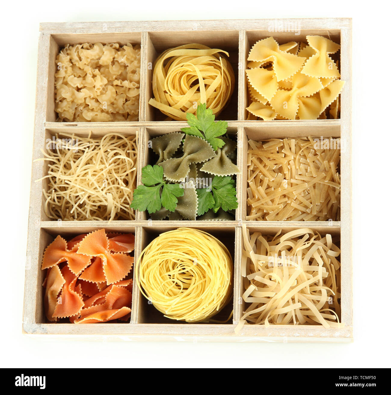 Nine types of pasta in wooden box sections close-up isolated on white ...