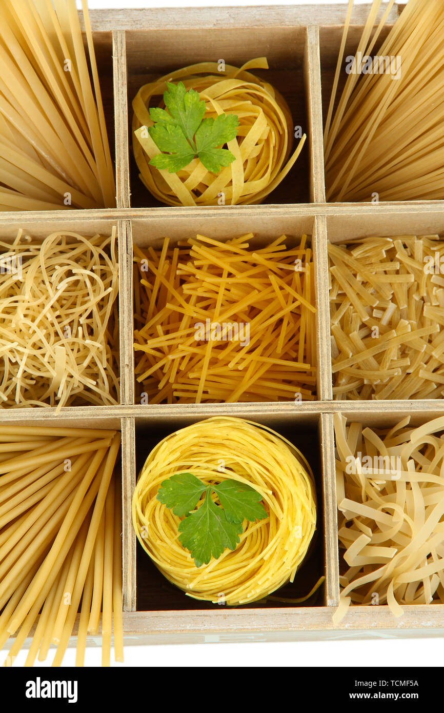 Nine types of pasta in wooden box sections close-up isolated on white ...