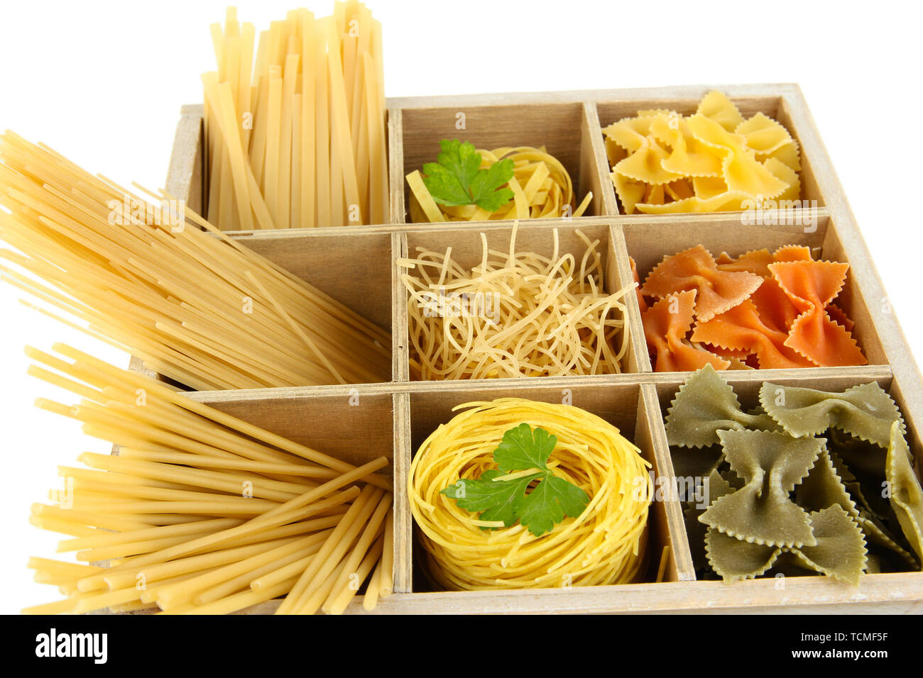 Nine types of pasta in wooden box sections close-up isolated on white ...