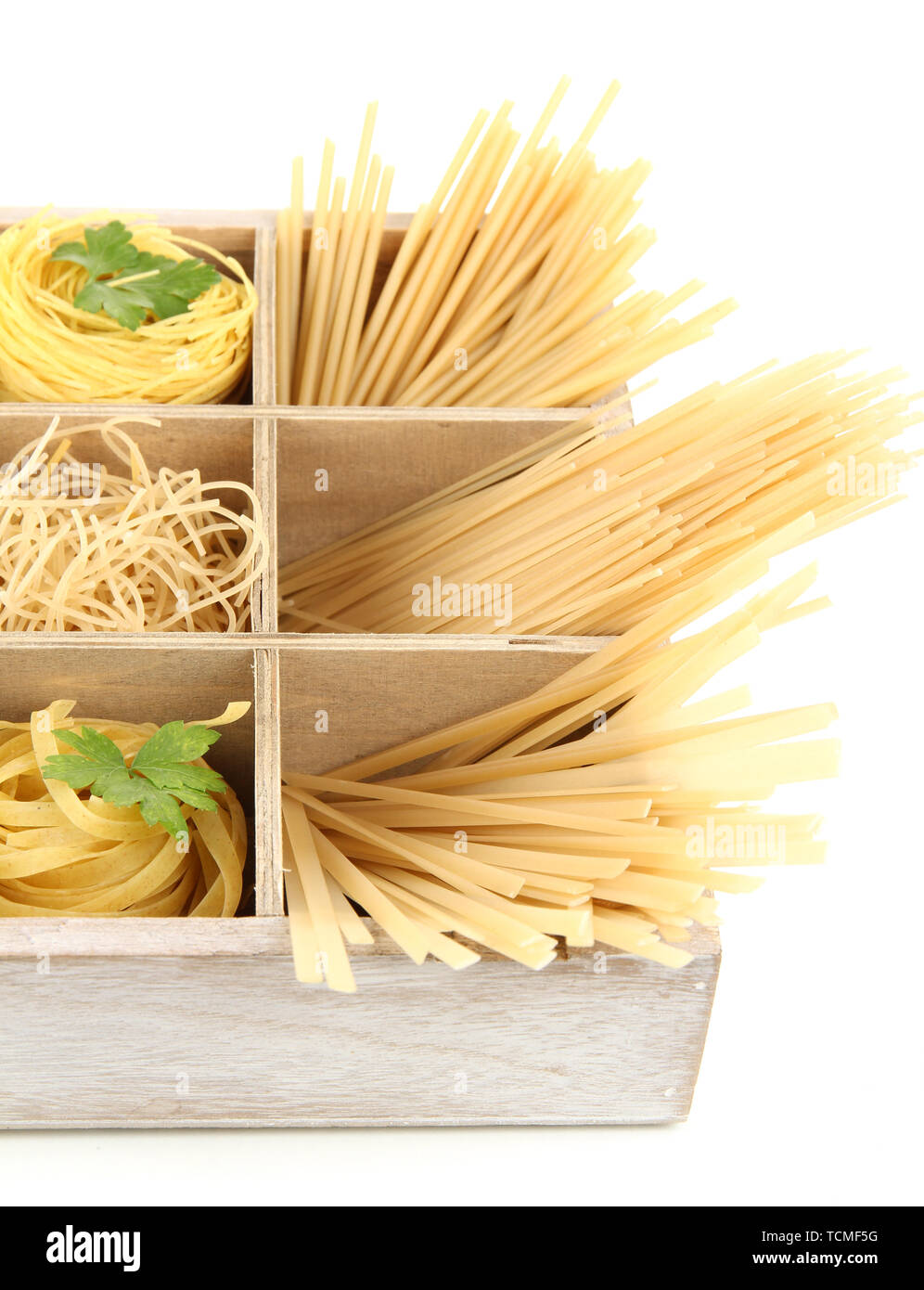 Nine types of pasta in wooden box sections close-up isolated on white ...
