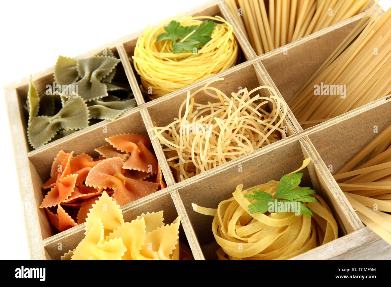 Nine types of pasta in wooden box sections close-up isolated on white ...