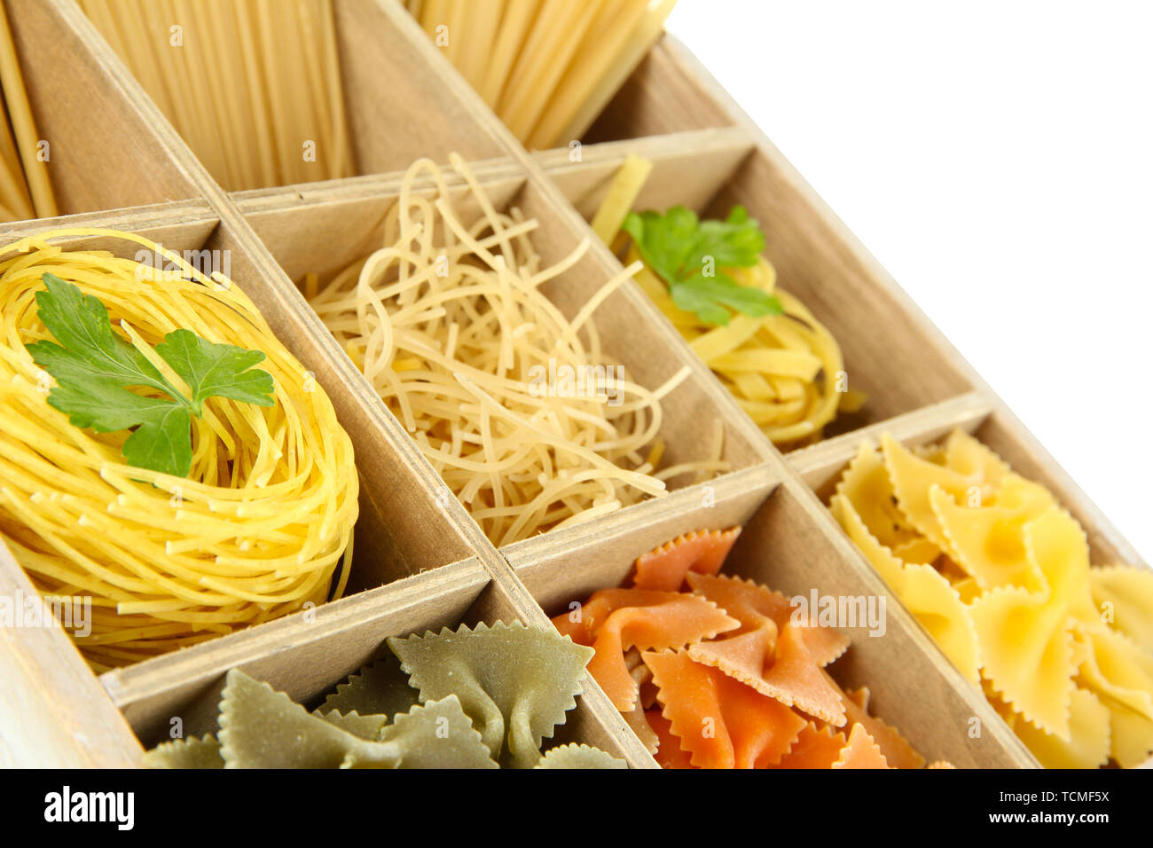 Nine types of pasta in wooden box sections close-up isolated on white ...