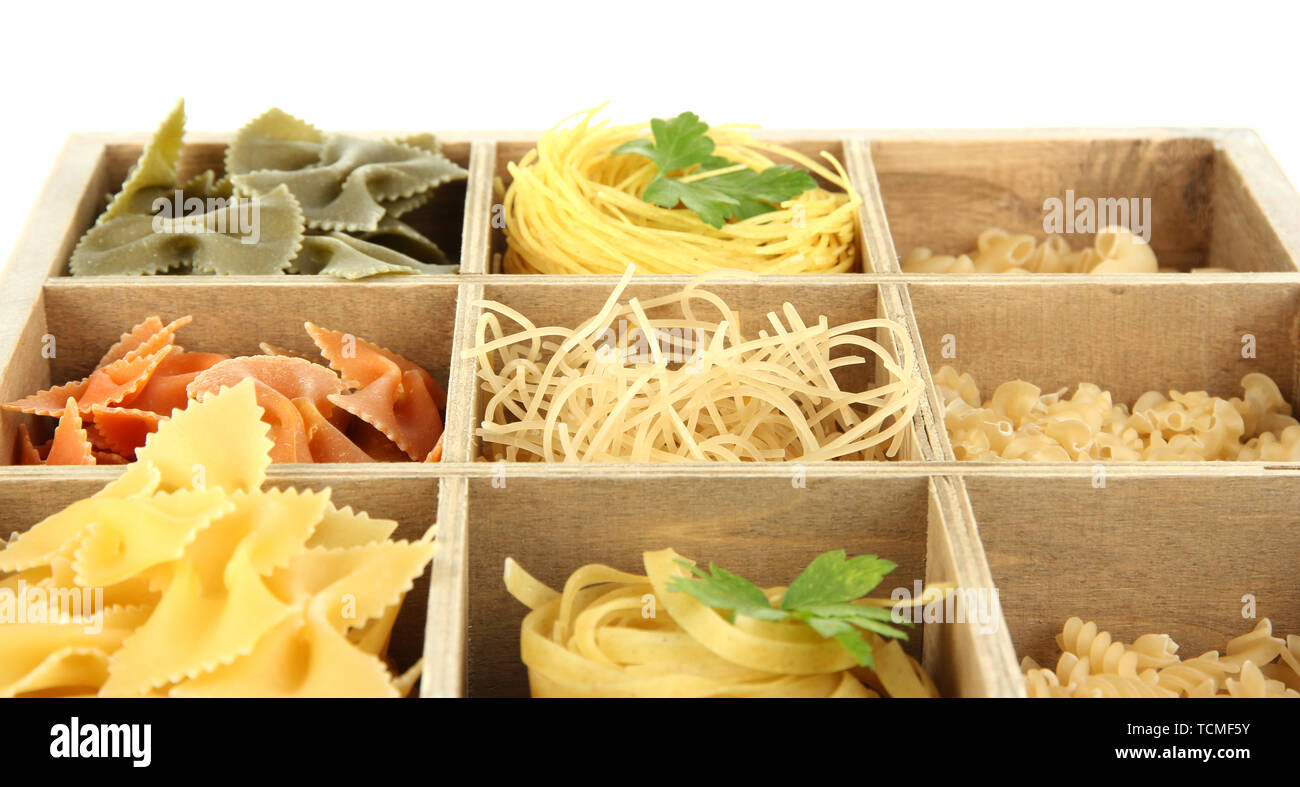 Nine types of pasta in wooden box sections close-up isolated on white ...