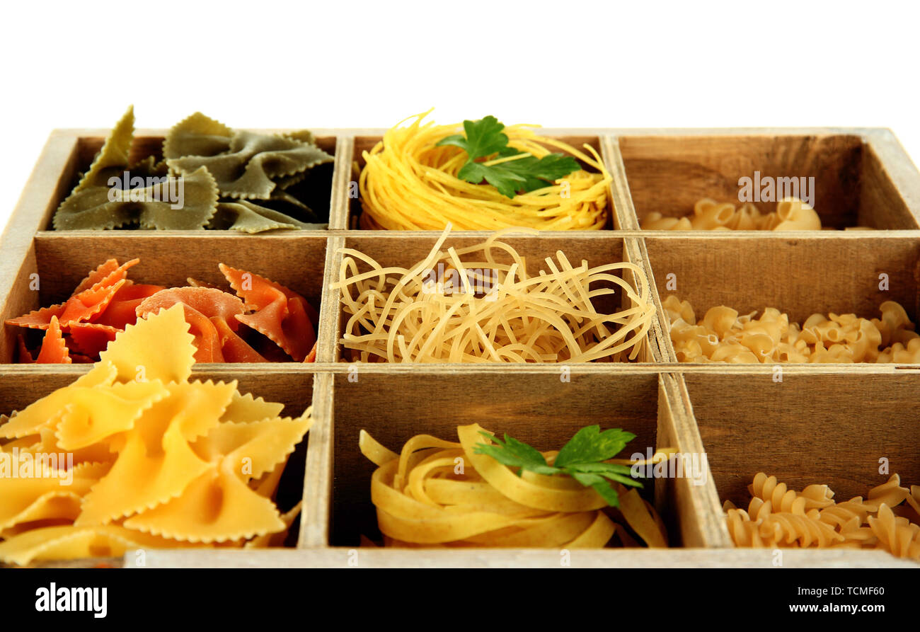 Nine types of pasta in wooden box sections close-up isolated on white ...