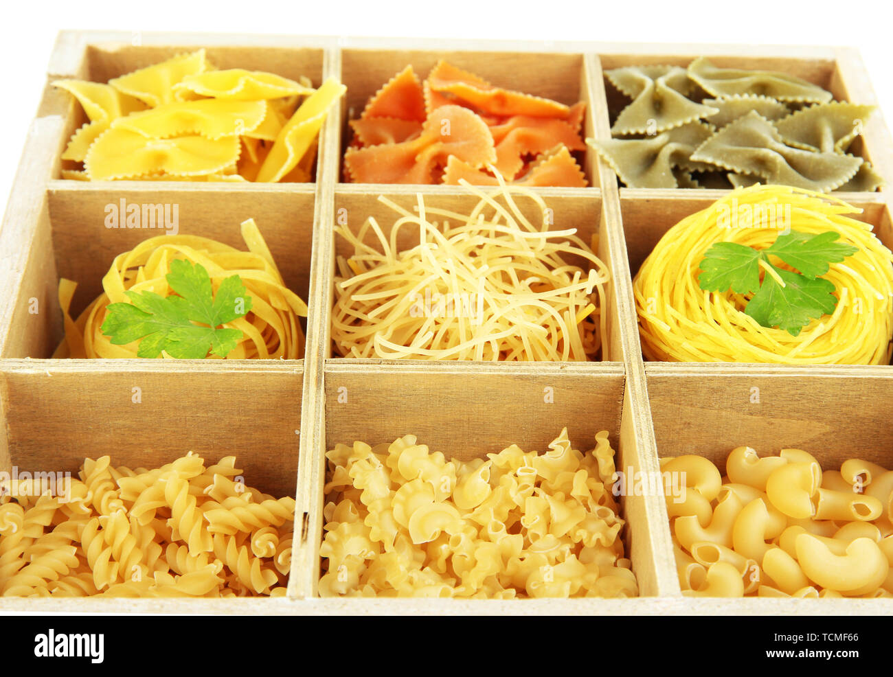 Nine types of pasta in wooden box sections close-up isolated on white ...