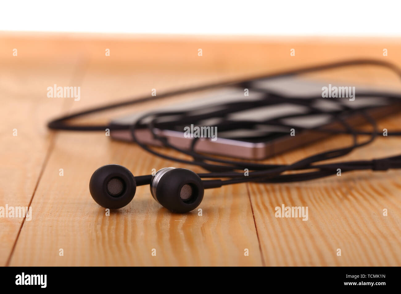 mobile phone with pair of earphone on wooden table Stock Photo - Alamy