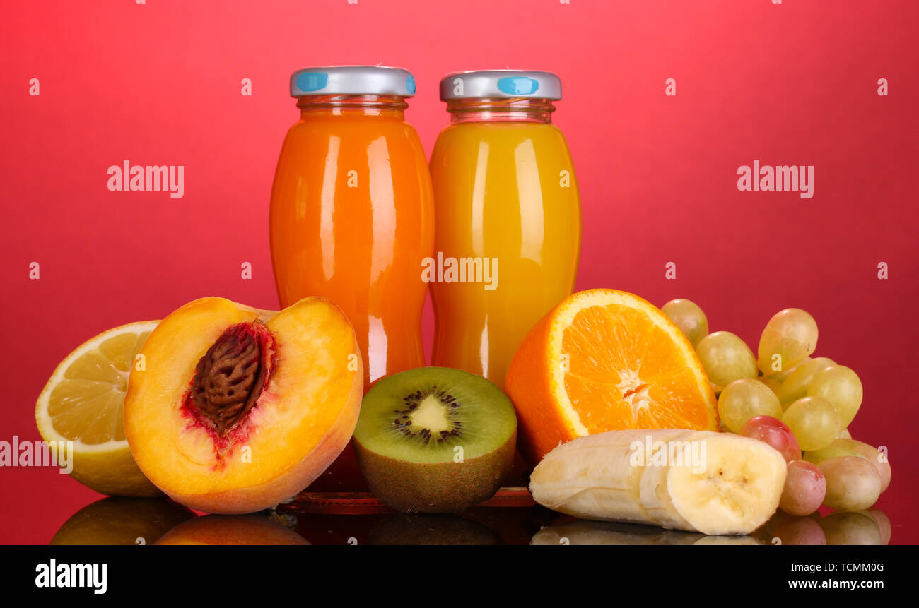 Delicious multifruit juice in a bottle and fruit next to it on pink ...