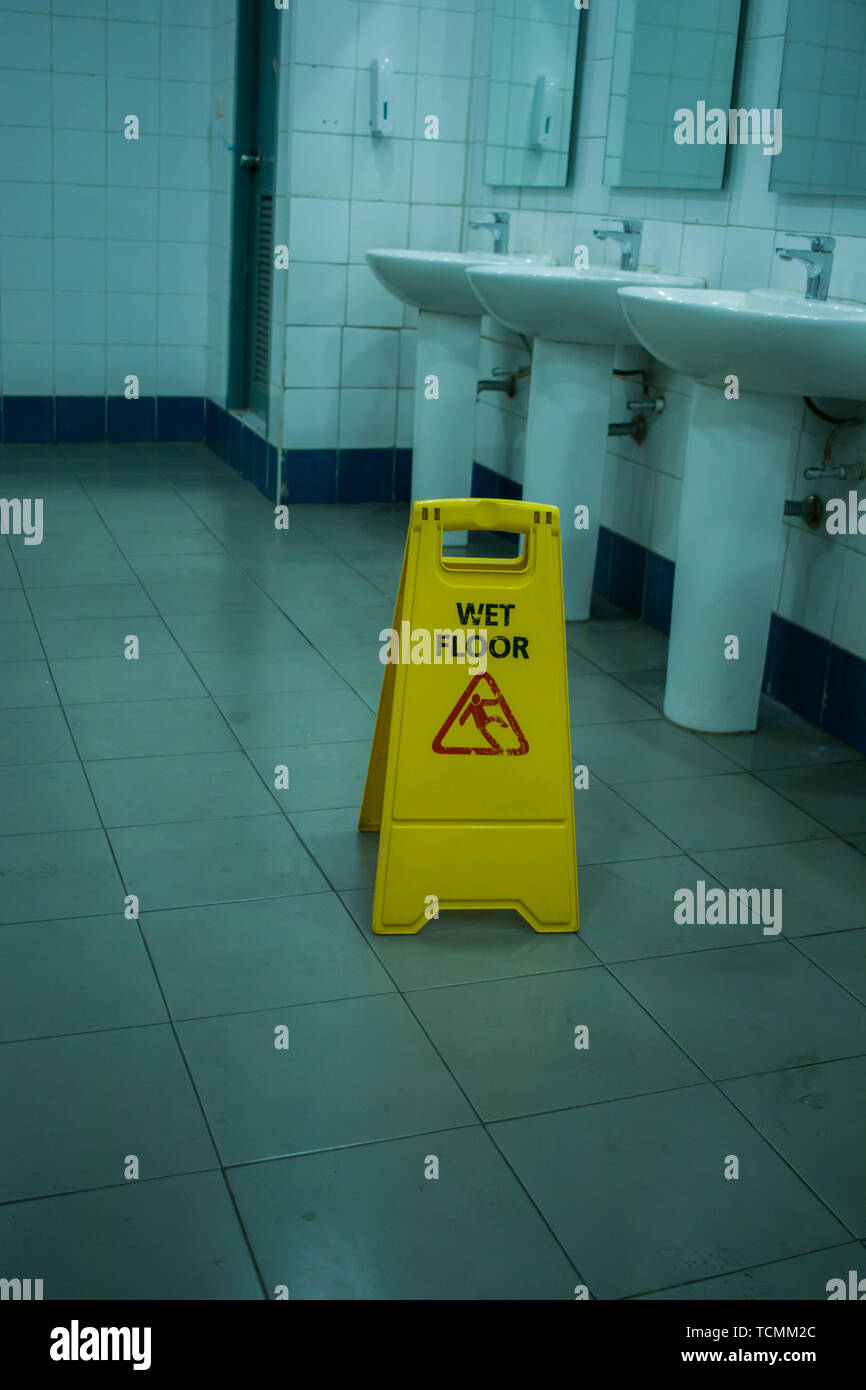 Yellow slippery warning sign, caution wet floor sign in the toilet room ...